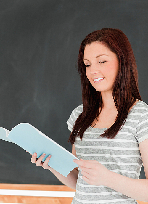 유토이미지 | Portait of a young woman reading her notes while standing in ...