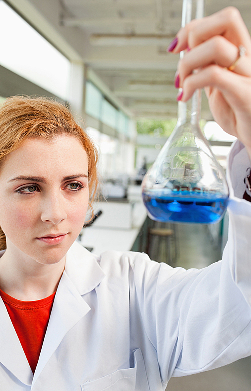 Portrait of a cute science student holding a blue liquid | 유토이미지 | 상세 ...