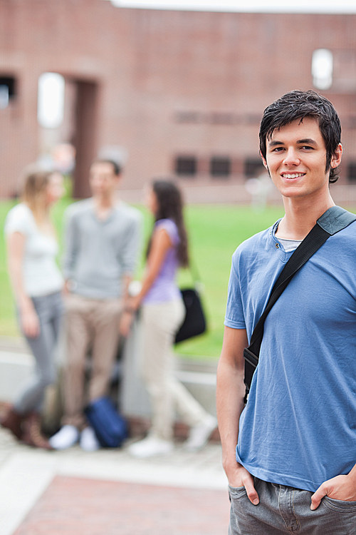 유토이미지 | Portrait of a handsome student posing while his classmates are ...