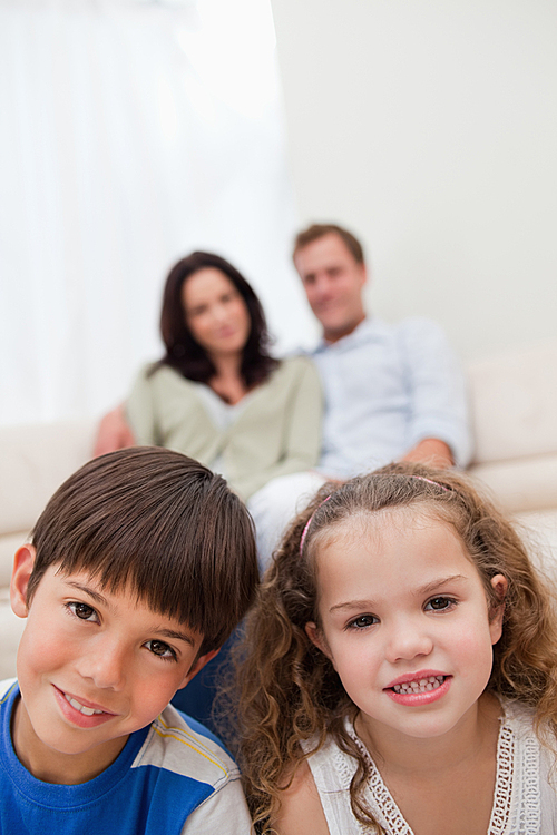Children sitting in the living room with parents behind them | 유토이미지 ...
