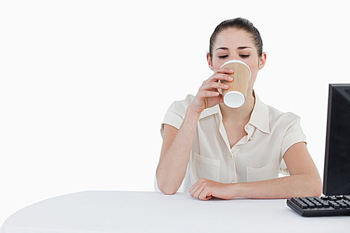 유토이미지 | Businesswoman drinking a takeaway tea while using a computer