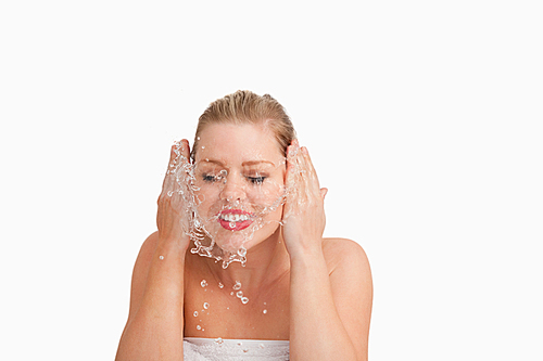 유토이미지 | Smiling blonde woman splashing her face