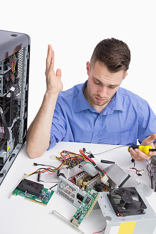 Confused young computer engineer fixing computer parts | 유토이미지 | 상세페이지 ...