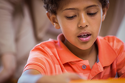 Schoolboy working hard at his desk at the elementary school | 유토이미지 ...