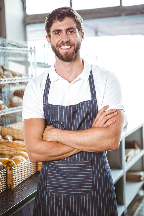 유토이미지 | Smiling server in apron arm crossed at the bakery