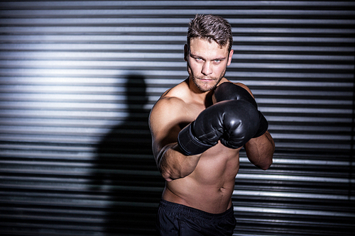 유토이미지 | Portrait of serious muscular boxer in crossfit gym