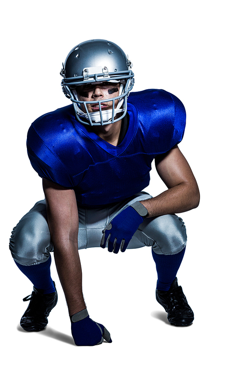 유토이미지 | American football player in uniform crouching against white ...