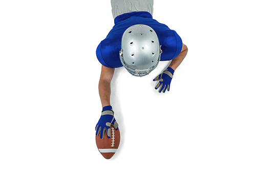 High angle view of American football player reaching towards ball ...