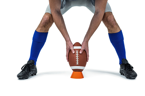 Low section of American football player placing the ball between his ...