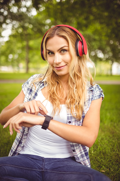유토이미지 | Portrait of smiling woman listening to music and using smartwatch