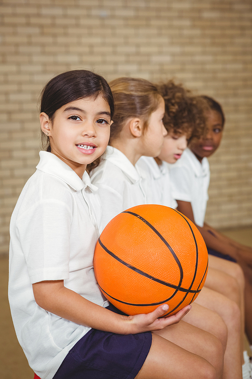 Student holding basketball with fellow players at the elementary school ...