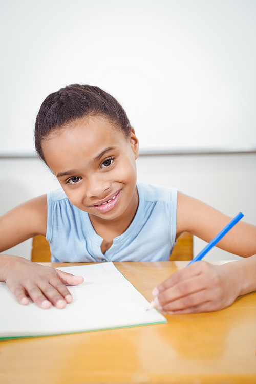 Pupil writing into a notebook at the elementary school | 유토이미지 | 상세페이지 ...