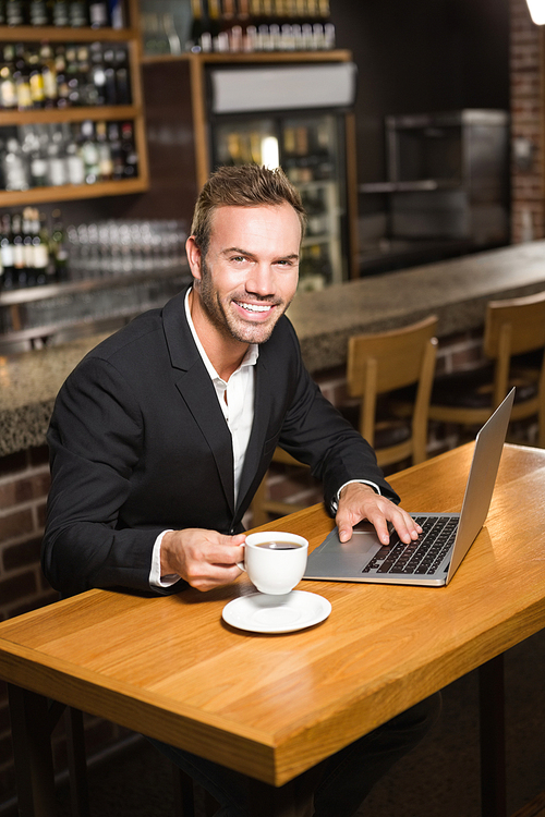 Handsome man using laptop and having a coffee in a pub | 유토이미지 | 상세페이지 ...