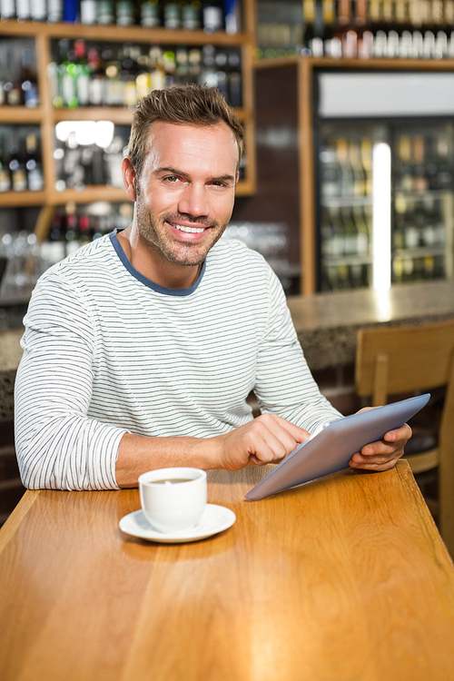유토이미지 | Handsome man using tablet computer in a pub