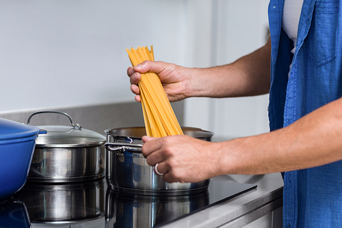 Close-up of man cooking spaghetti in the kitchen | 유토이미지 | 상세페이지 | 베이직샵 ...