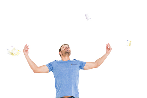 Young man throwing currency notes in excitement on white background ...