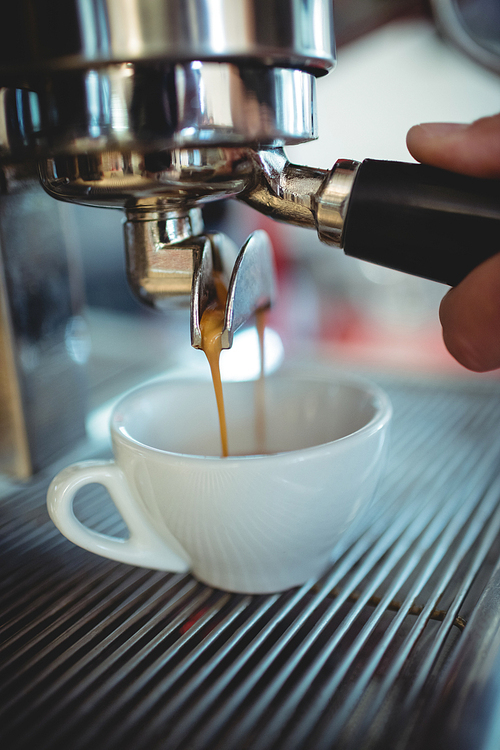 유토이미지 | Cropped image of waiter holding espresso machine handle at cafe