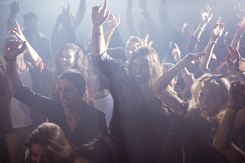 Full frame shot of cheerful fans dancing at nightclub during music ...