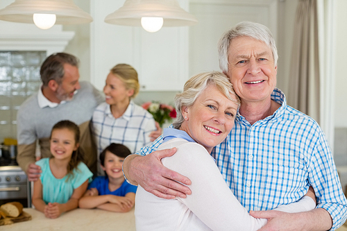 Portrait of happy senior couple embracing each other in kitchen and ...
