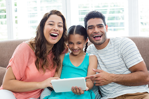 유토이미지 | Portrait of parents and daughter using digital tablet in living ...