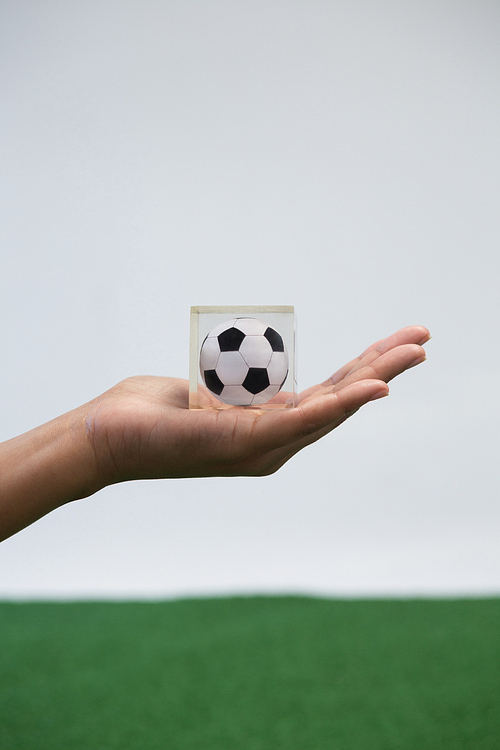유토이미지 | Close-up of hand holding acrylic football cube against white ...