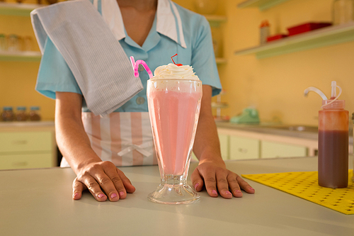 유토이미지 | Mid section of waitress with ice cream on table in restaurant