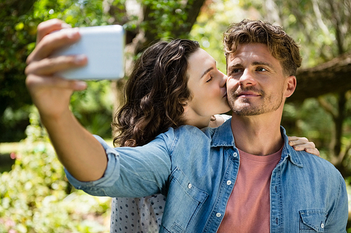 Couple taking selfie from mobile phone in garden | 유토이미지 | 상세페이지 | 베이직샵 ...