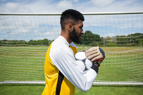 Side view of goalkeeper holding football in front of goal post | 유토이미지 ...