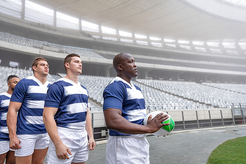 Side view of diverse male rugby player standing in a row at the ...