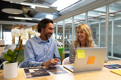 Side view of Caucasian male and female graphic designers discussing ...