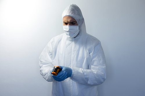 Caucasian man wearing lab overalls and a face mask standing in an empty ...