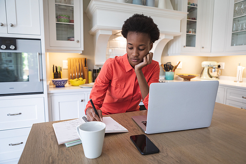 유토이미지 | Mixed race woman spending time at home, sitting by a table in ...