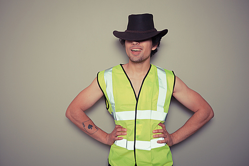 유토이미지 | A cheeky cowboy builder is wearing a high visibility vest