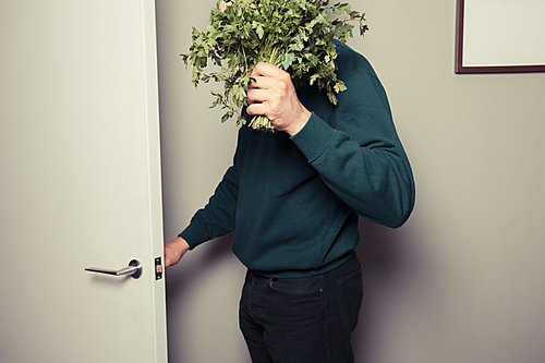 A young man with a big bunch of parsley in his hand is answering the ...