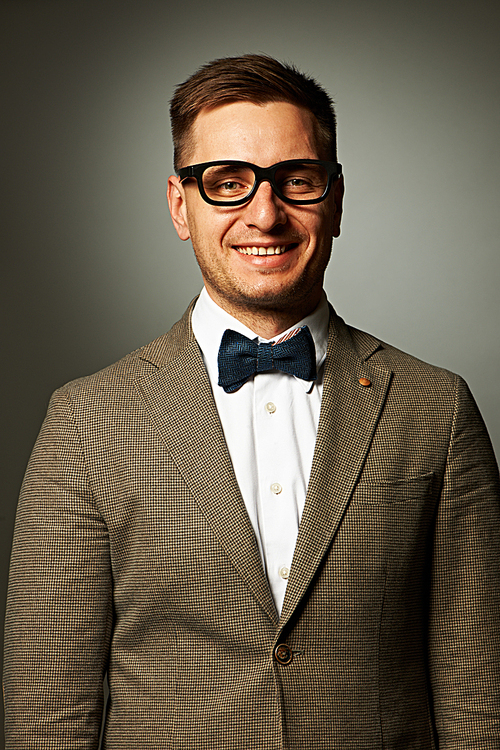 유토이미지 | Confident nerd in eyeglasses and bow tie against grey background
