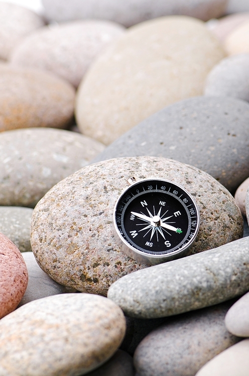 유토이미지 | Navigation compass on stone pebbles