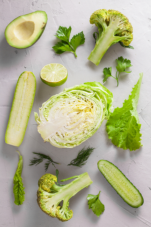 Composition of fresh green cut in half vegetables on a white background ...