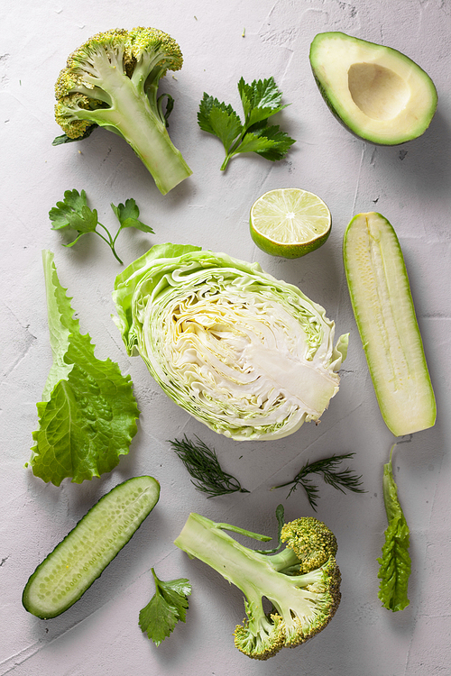 Composition of fresh green cut in half vegetables on a white background ...