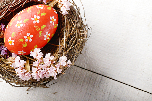 유토이미지 | Rustic style painted red easter egg in the nest on white table