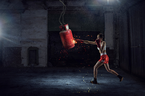유토이미지 | Young pretty woman boxing in desolate building. Mixed media