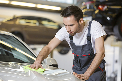 유토이미지 | Young automobile mechanic cleaning car in repair shop