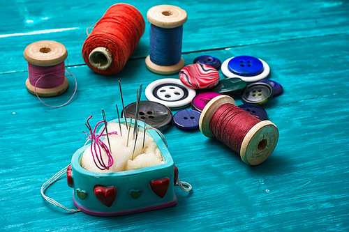 유토이미지 | thread buttons for crafts on turquoise wooden background