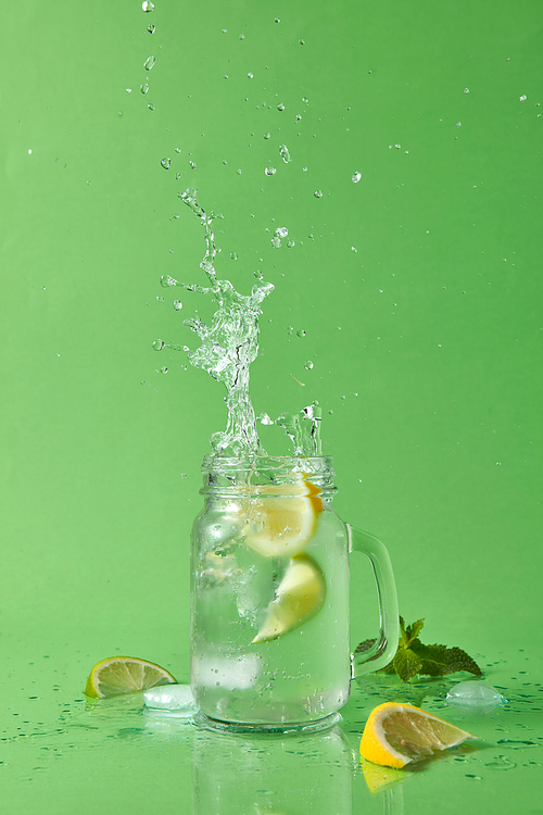 유토이미지 | Ice cubes falling in lemonade with splashes and drops isolated on green background ...