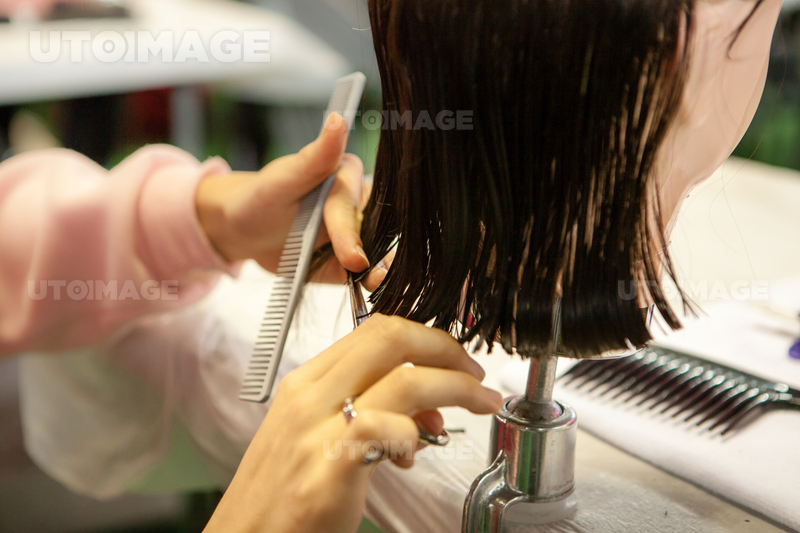 국가미용자격증을 취득하기위한 미용실에서 머리를 자르는 모습중 가위와 머리빗이 부각되는 근접촬영뷰티산업 미용실 염색 및 머리 커트 클로즈업 미용실 염색 및 머리 커트
