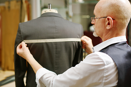 유토이미지 | Modern tailor measuring back of jacket on mannequin