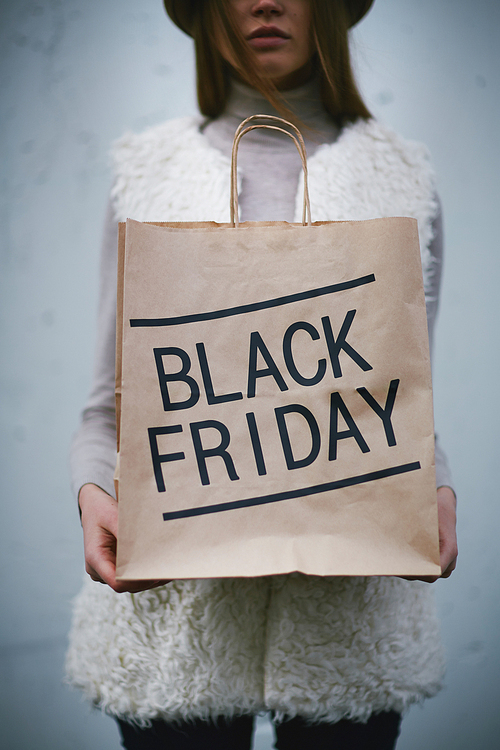 Young buyer holding Black Friday bag | 유토이미지 | 상세페이지 | 베이직샵 | 사진 | 20614303