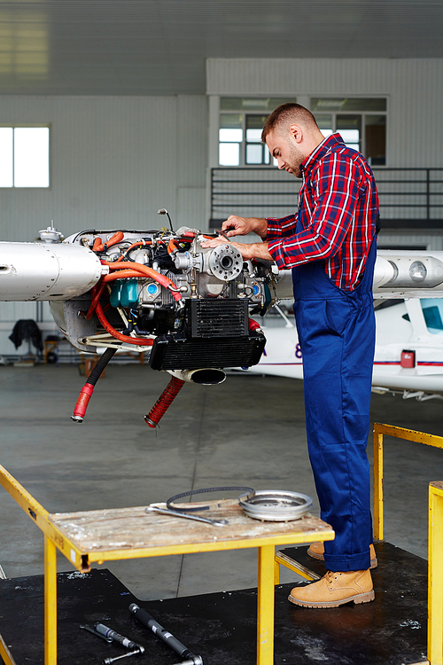 Airplane service crew working on preflight maintenance: young mechanic ...