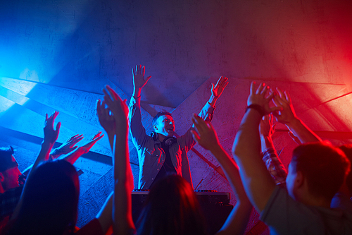 유토이미지 | Happy deejay entertaining youthful audience at night