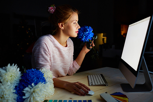 Profile view of pretty young floral designer sitting in front of modern ...