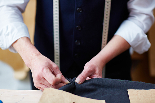 Closeup of skilled tailor working in atelier: pinning and stitching ...